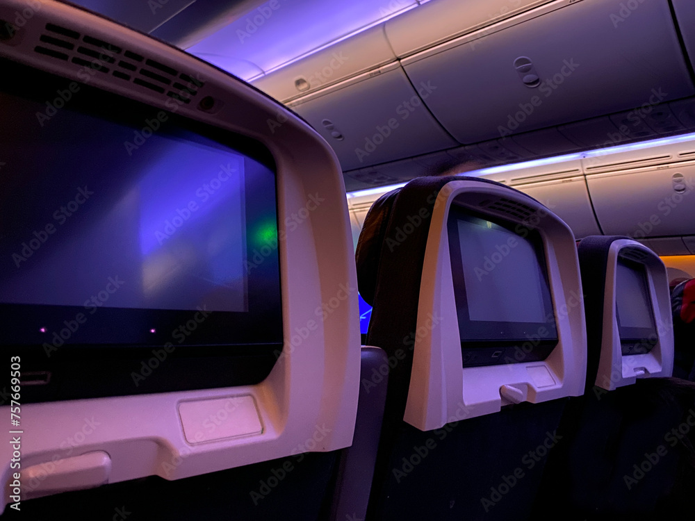 Interior of an airplane with digital monitor to watch movies during the ...