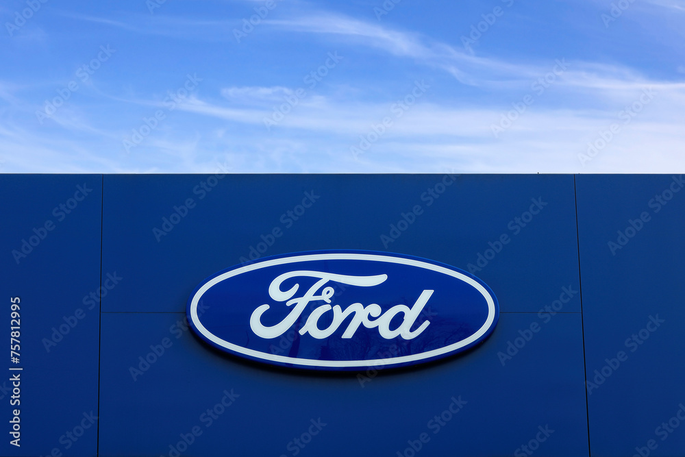 Ford Motor Company logo at dealership against blue fair weather sky ...