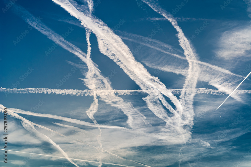 Gewirr von sich teilweise auflösenden Kondensstreifen am blauen Himmel ...
