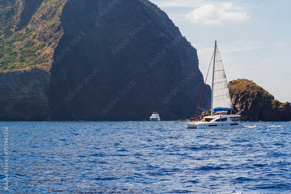 Sea view of a mountain range and the sailing boat. Salina is one of the ...