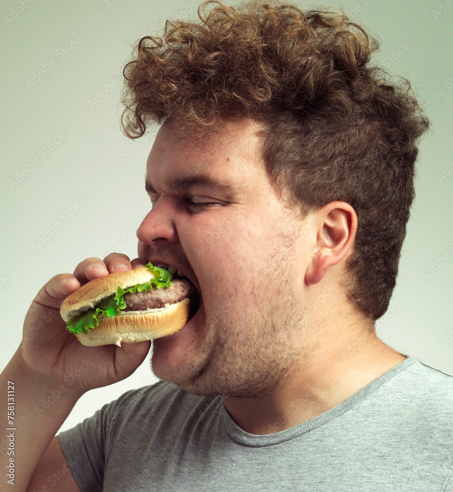 Obesity, weight gain and fast food for man in studio with hamburger for ...