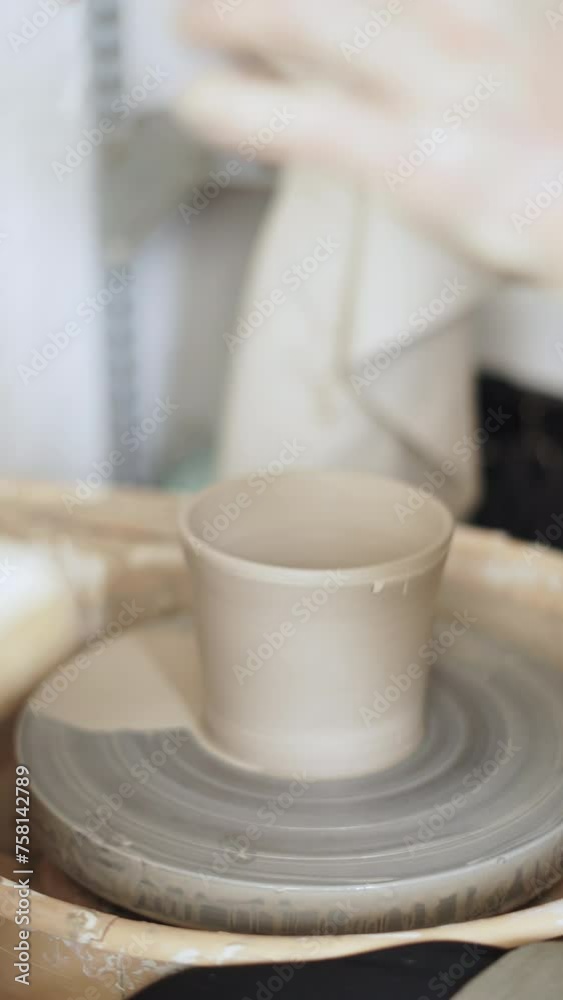 A Latina ceramist skillfully employs a nylon wire to gently separate a ...