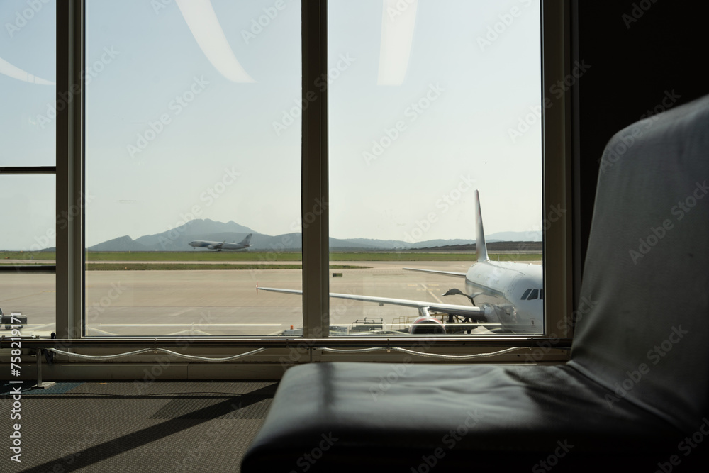 Image from inside the airport boarding gate with large windows overlooking the planes and the ...