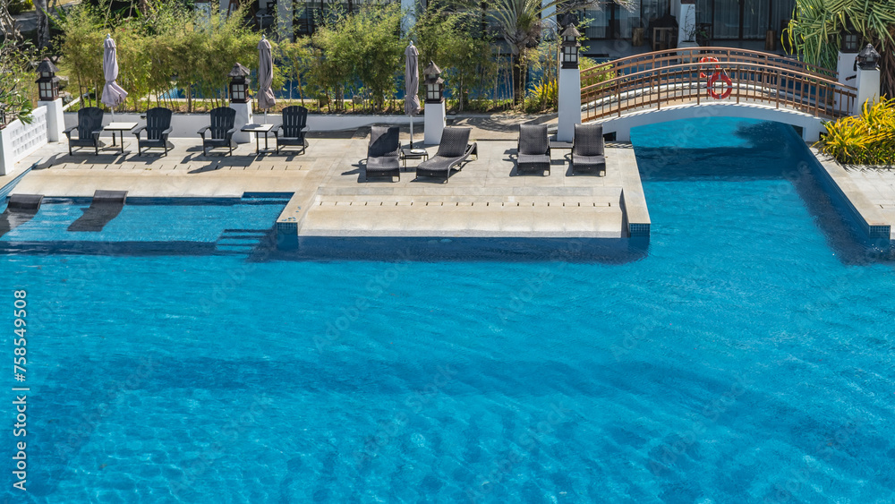 Top view of a large swimming pool with clear blue water. An arched ...