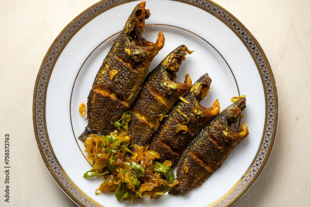Delicious fried koi fish garnished with chopped onions and green ...