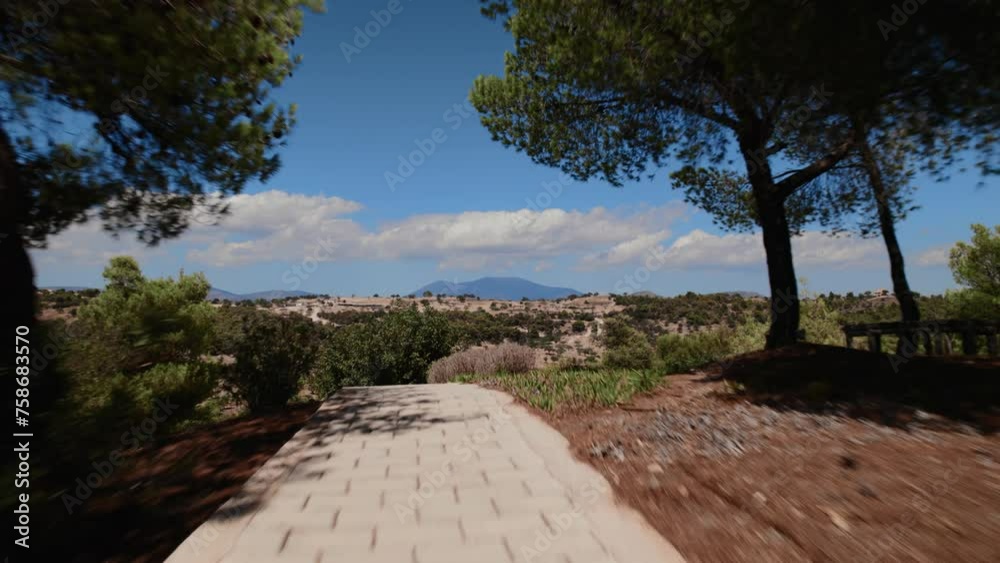 Drone flying along a small pathway revealing a Greek hill with olive ...
