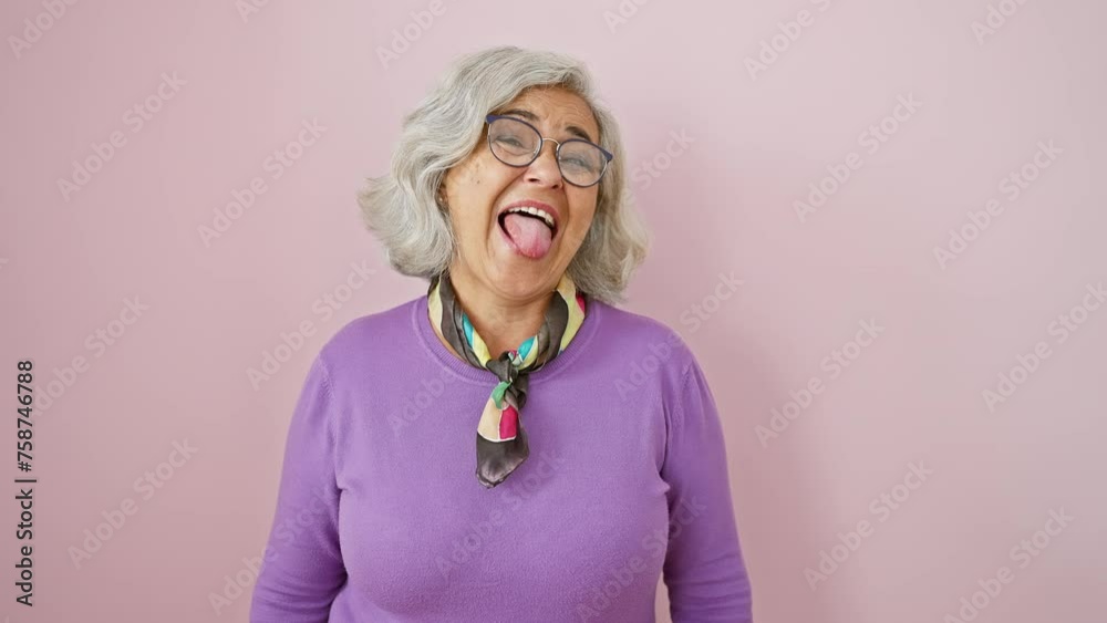 Cheeky middle age woman with grey hair, wearing glasses and sticking ...