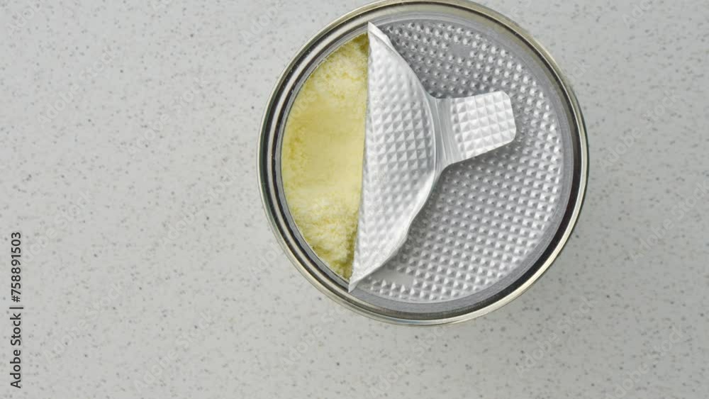 Powdered milk container with open lid, highlighting the fine texture ...