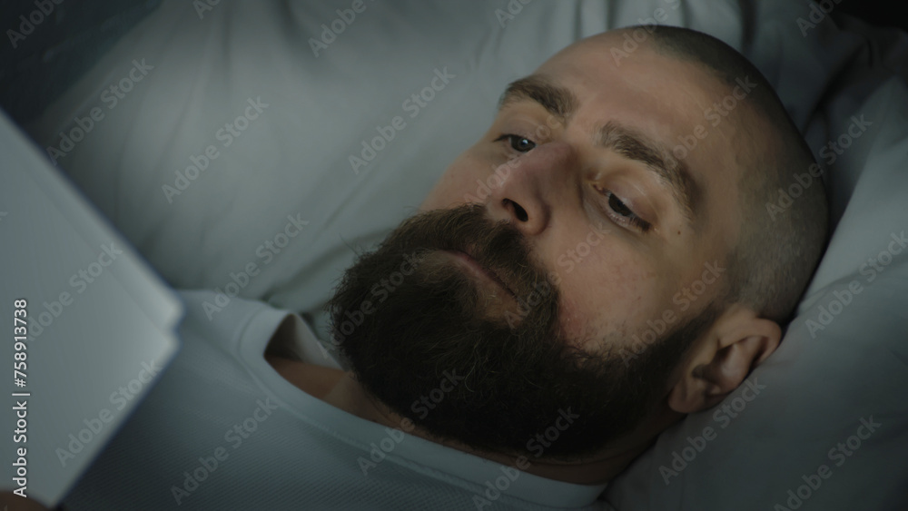 Close up of male prisoner lying on bed in prison cell, smiling and ...