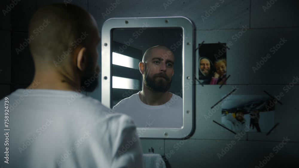 Reflection of male criminal in the mirror looking out the window in ...