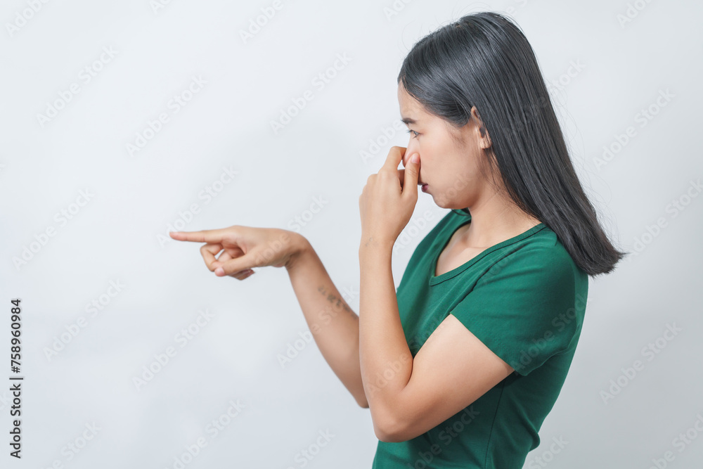 Young Asian frustrated woman with green t-shirt pinches her nose with ...