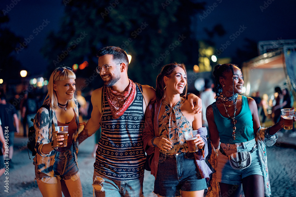 Group of happy festival goers attending open air music concert at night ...