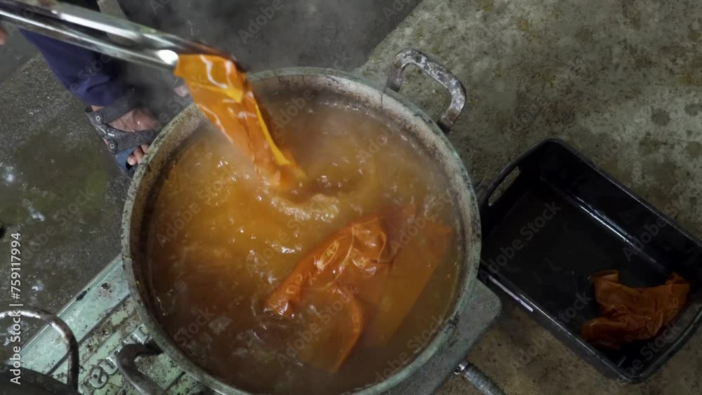 Close up 4k footage of students learning to dye traditional batik cloth ...