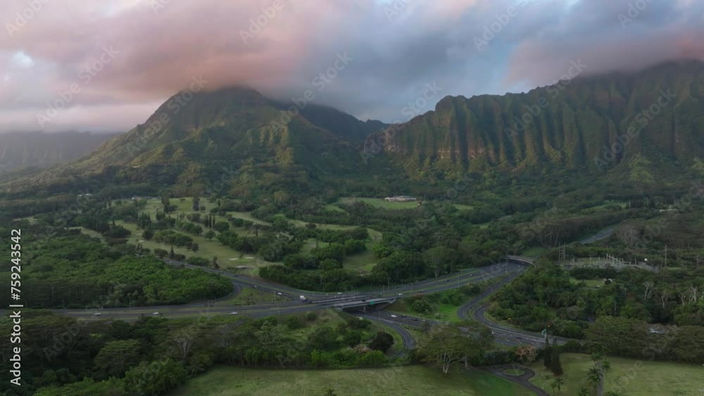 Cars driving by freeway along volcano mountain ridge covered by ...