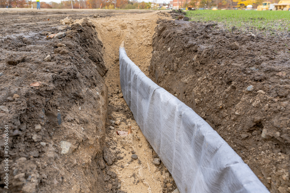 Construction photo of natural turf athletic field vertical edge drain ...