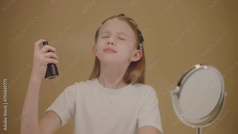 Pretty teenage girl spraying facial spray or soothing moisturizing ...