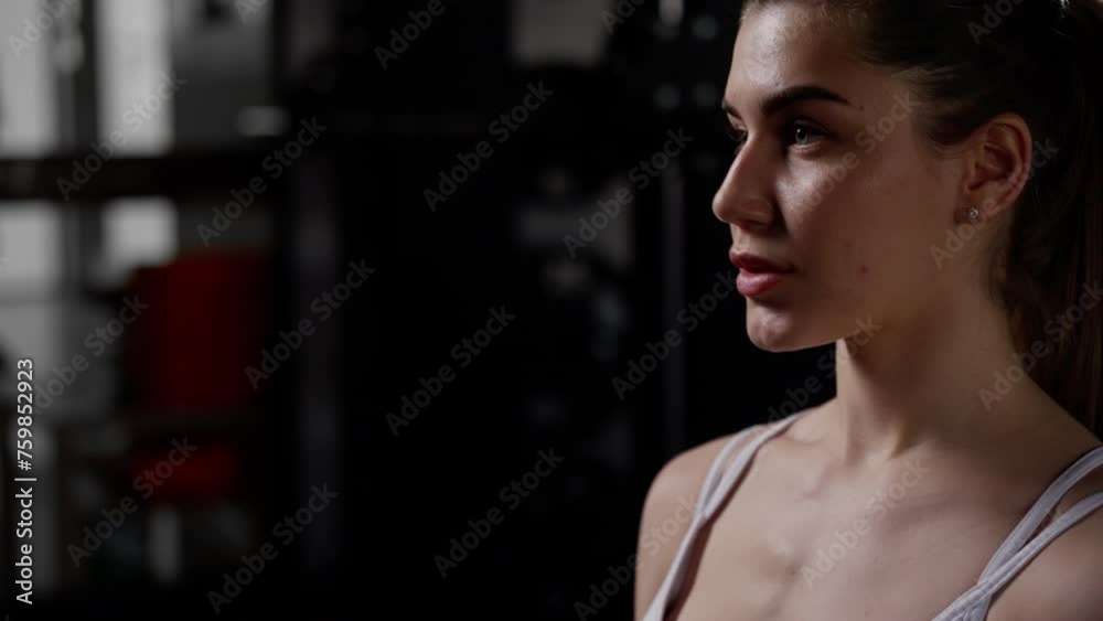 Side profile of a female athlete doing a focused bicep workout at the ...