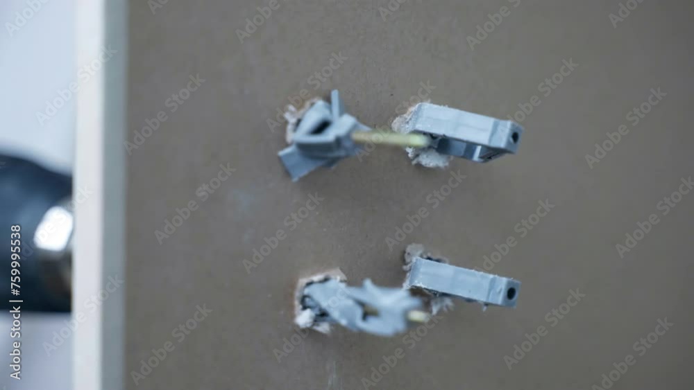 Process of screws fixation in drywall holes with plastic dowels ...