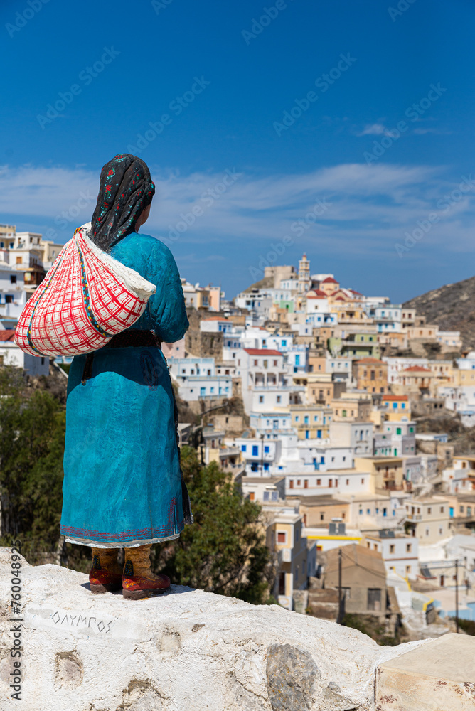 Statue of a greek woman in a traditional outfit looking over Olympos ...