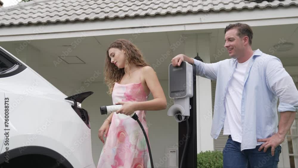 Happy and lovely couple with eco-friendly conscious recharging electric ...