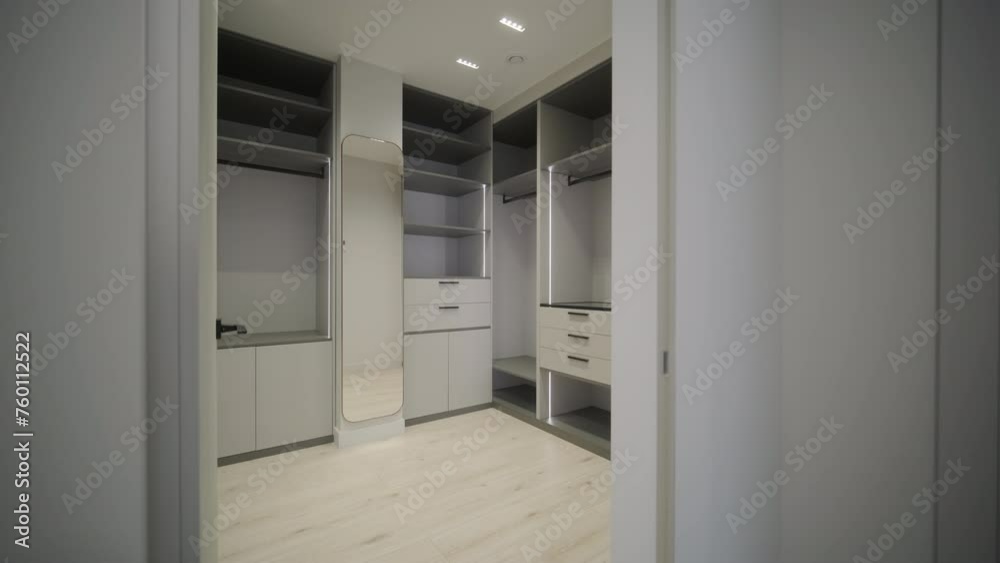 A well-organized wardrobe room displays tall, modern cabinets with ...
