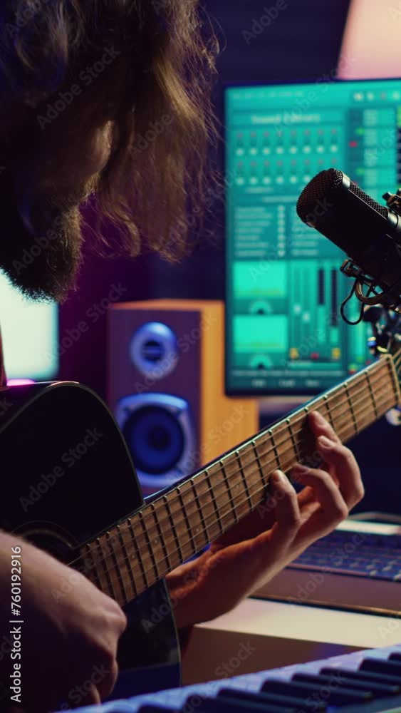 Vertical Video Artist composing a song with his acoustic guitar in home ...