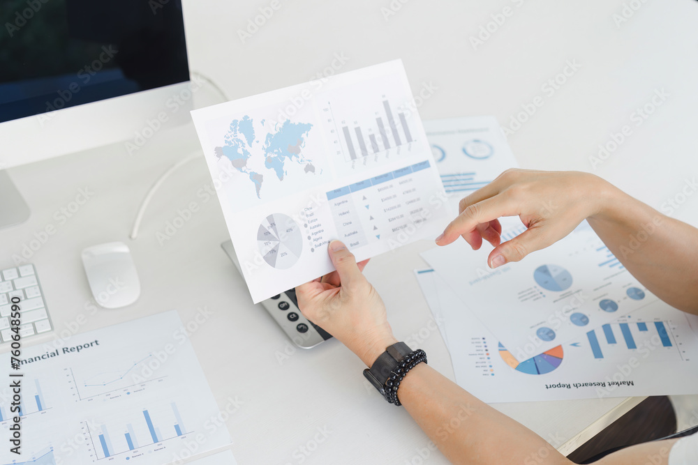 Hands of a professional examining a global market analysis report with ...