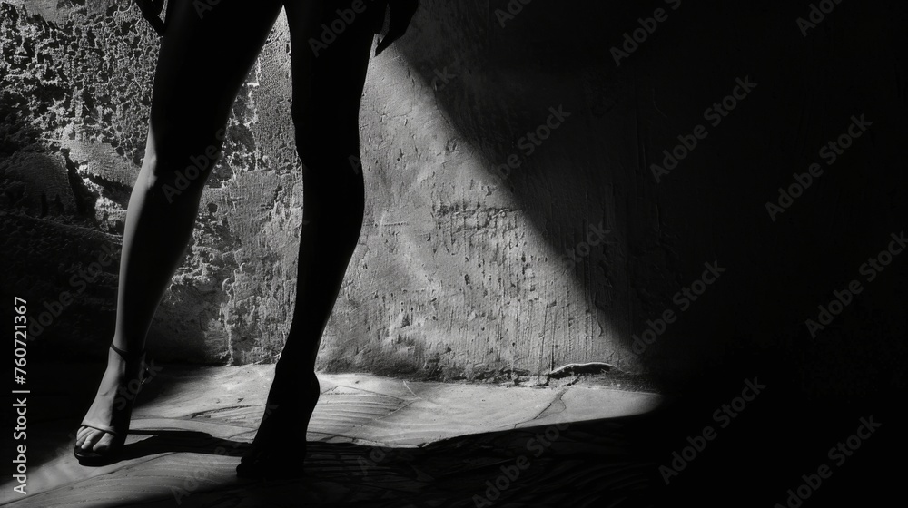 Silhouette of a young woman in a dark room with shadows. The outline of ...