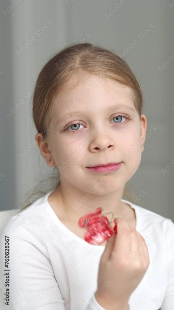 A child's smile with a plate for straightening teeth, close-up. Braces ...