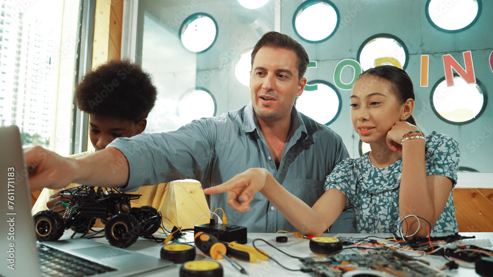 Caucasian student asking teacher about code and pointing at laptop ...