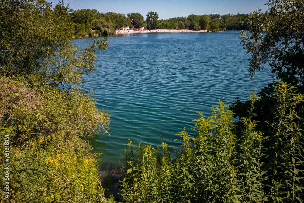 Lac de gravière avec une plage au loin Stock Photo | Adobe Stock