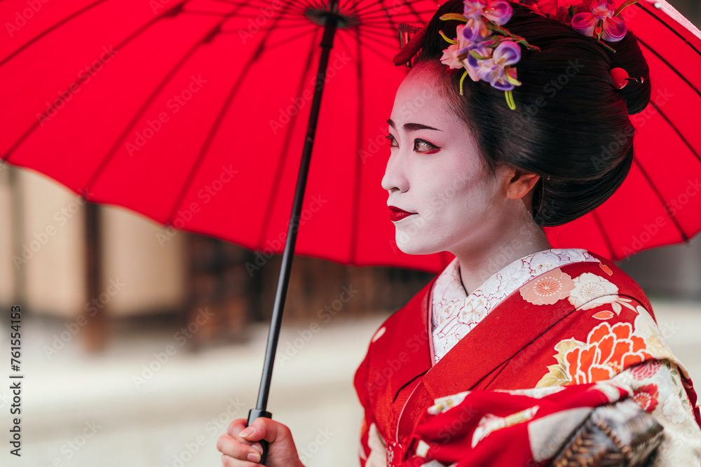 The stark red of a geisha's kimono stands out, with her porcelain-like ...