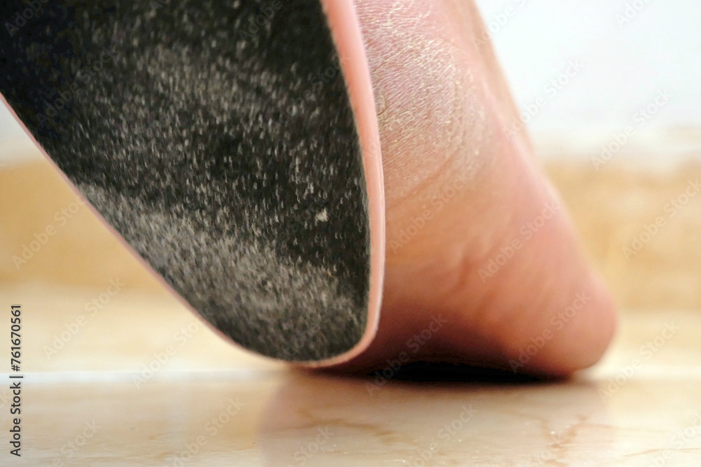 Woman using foot file for removing dead skin from feet at home, woman ...