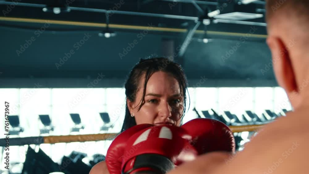A determined female athlete is practicing boxing in a professional ring ...
