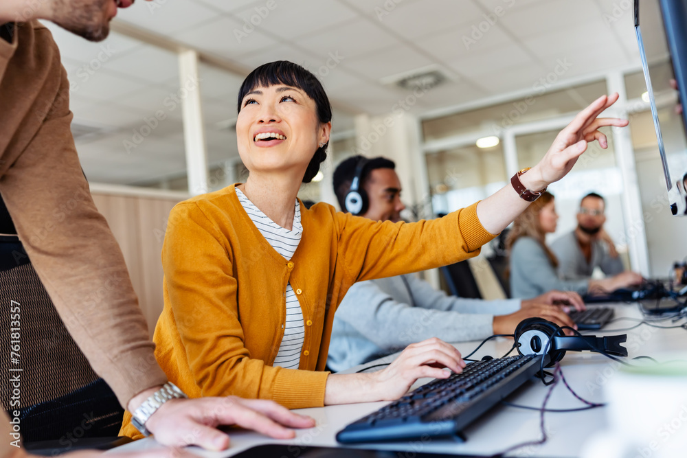 In their office, a multi-ethnic group of IT professionals works ...