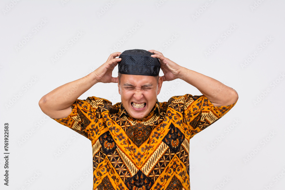 Seething Indonesian man in batik shirt and kopiah expressing ...