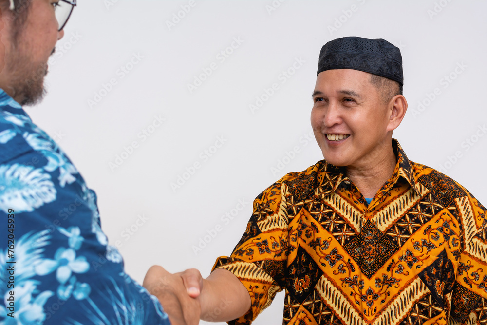 An engaging moment of cultural greeting, showing an Indonesian man in ...