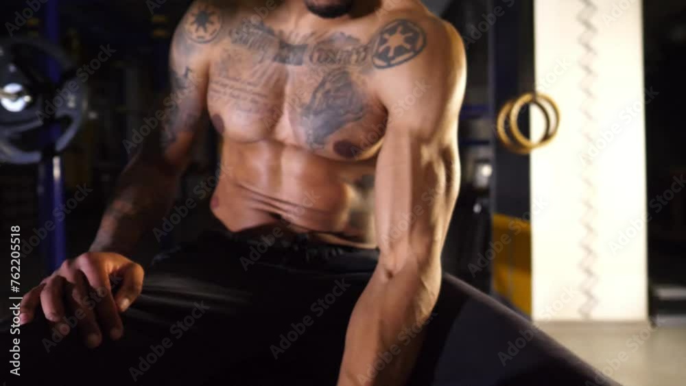 Muscular afro american sportsman training his biceps with dumbbell at ...