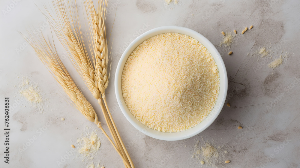 Raw semolina flour, also known as Rava powder, in a white bowl with two ...
