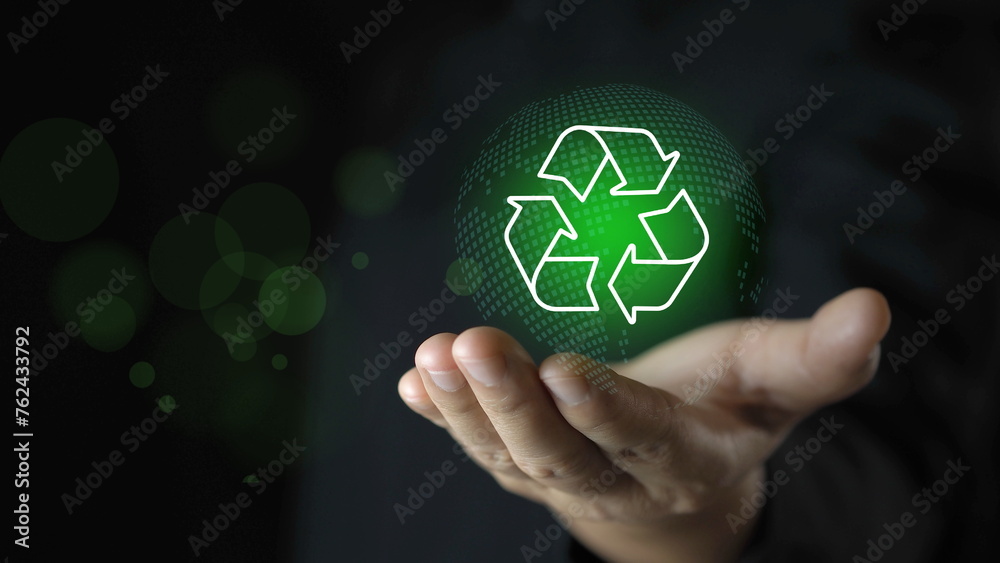 Businessman holding globe with recyclable symbol on virtual screen ...