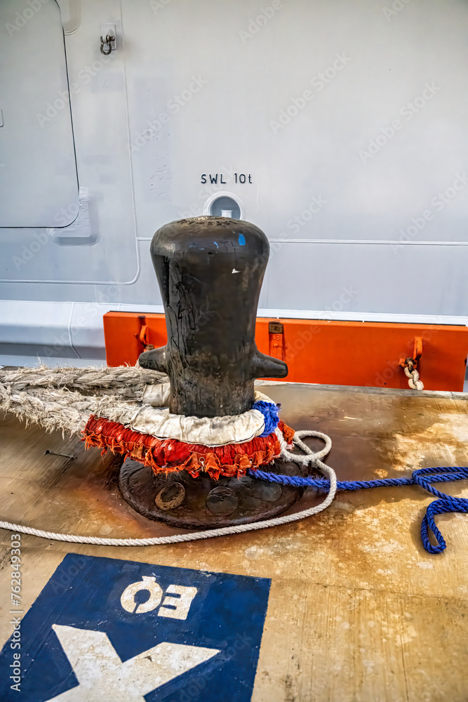 Detailed view of a ship's mooring bollard with colorful ropes and SWL ...