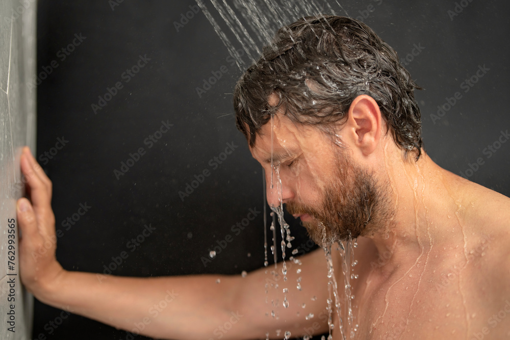 Man taking shower. Man washing hair with shampoo under water falling ...