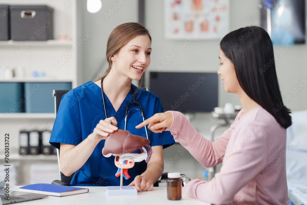 Caucasian liver professional female doctor explain to asian female ...