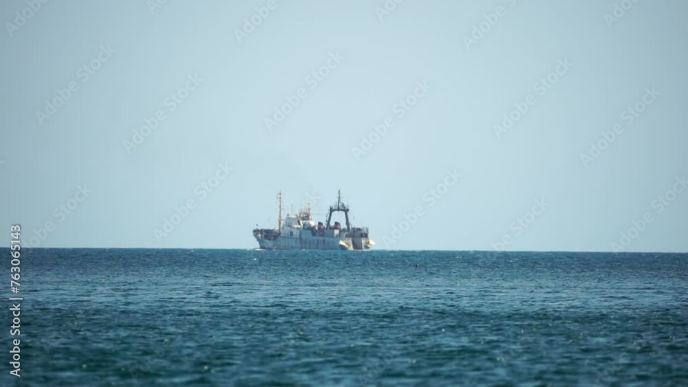 Fishing boat trawler catches fish while sailing on sea. A commercial ...