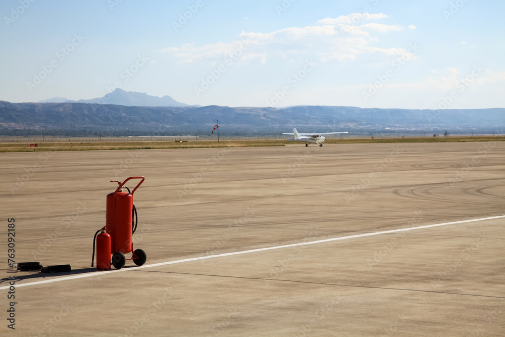 Propeller small training plane and fire extinguisher on the runway ...