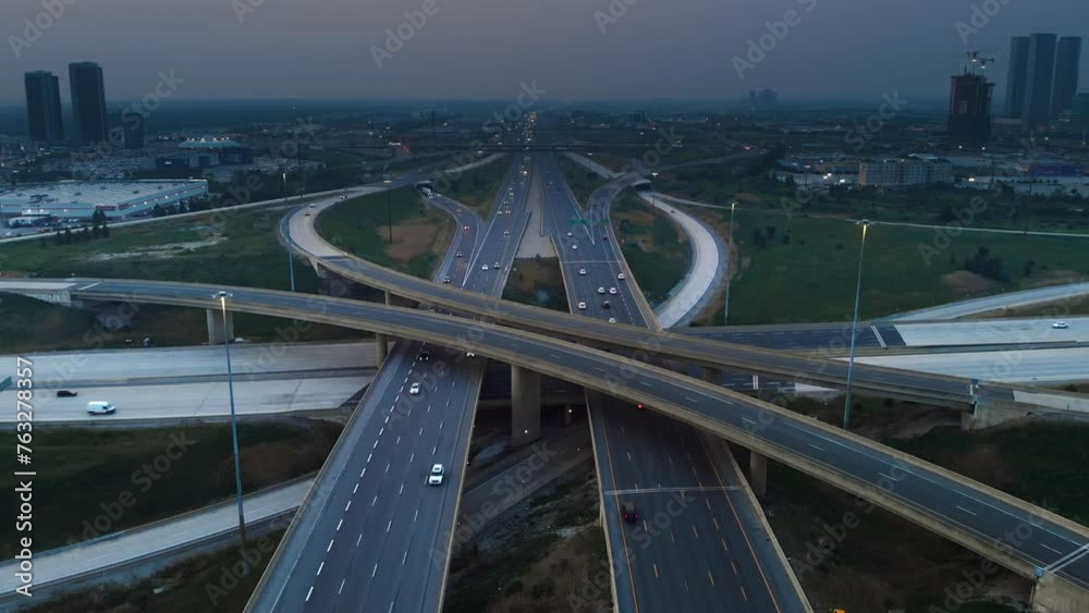 Cars navigating multi-level interchange in America. Evening aerial ...