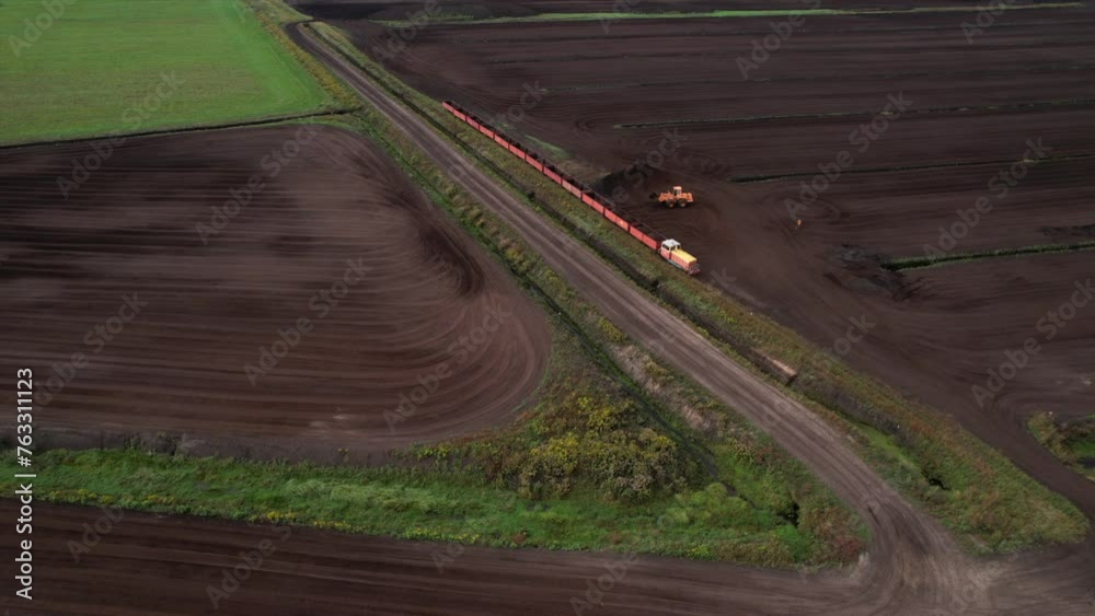 Peat extraction. Wheel loader load peat in freight cars. Aerial view of ...