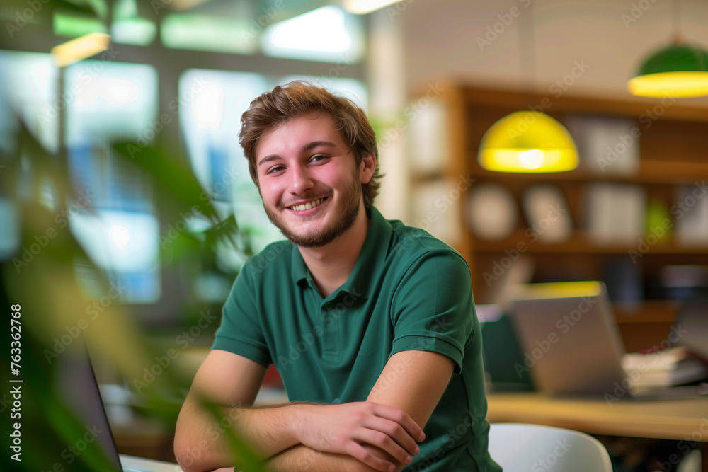smiling male staff at work wearing green polo collar shirt in office ...