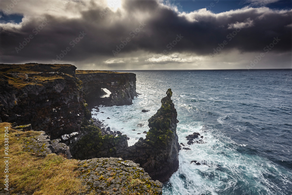 Lava cliffs at Skalasnagi with dramatic storm clouds, at the ...