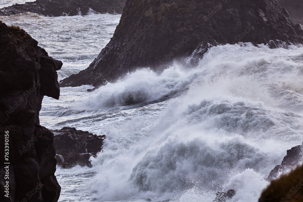 Storm surf along a rugged coastline with black rock at Arnastapi ...